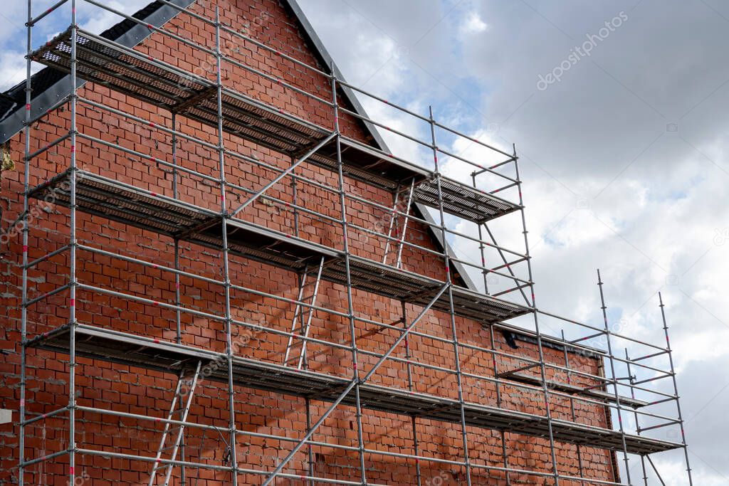 Andamios grandes en la fachada de una casa para renovar y aislar la ...