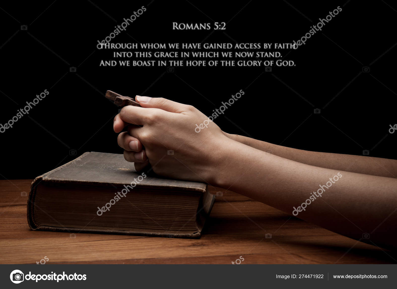 Manos sosteniendo una cruz en la Santa Biblia con versículo Romanos 5: ...