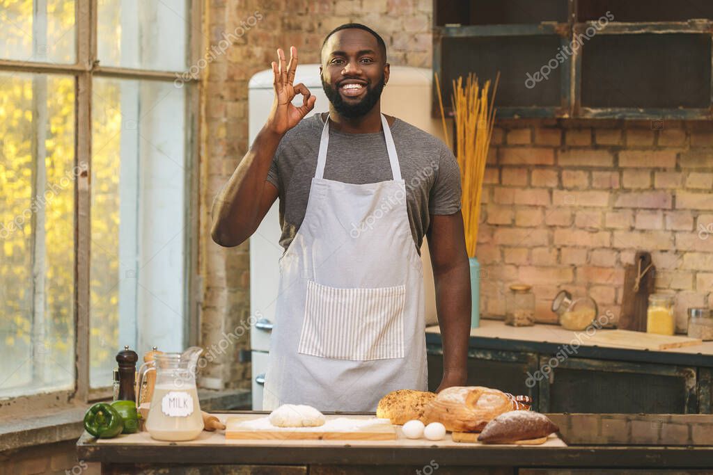 Proceso de cocción. Alegre de piel oscura afroamericano usa delantal ...