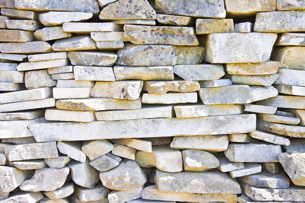 Stone wall built with blocks and marble slabs simply placed over ...