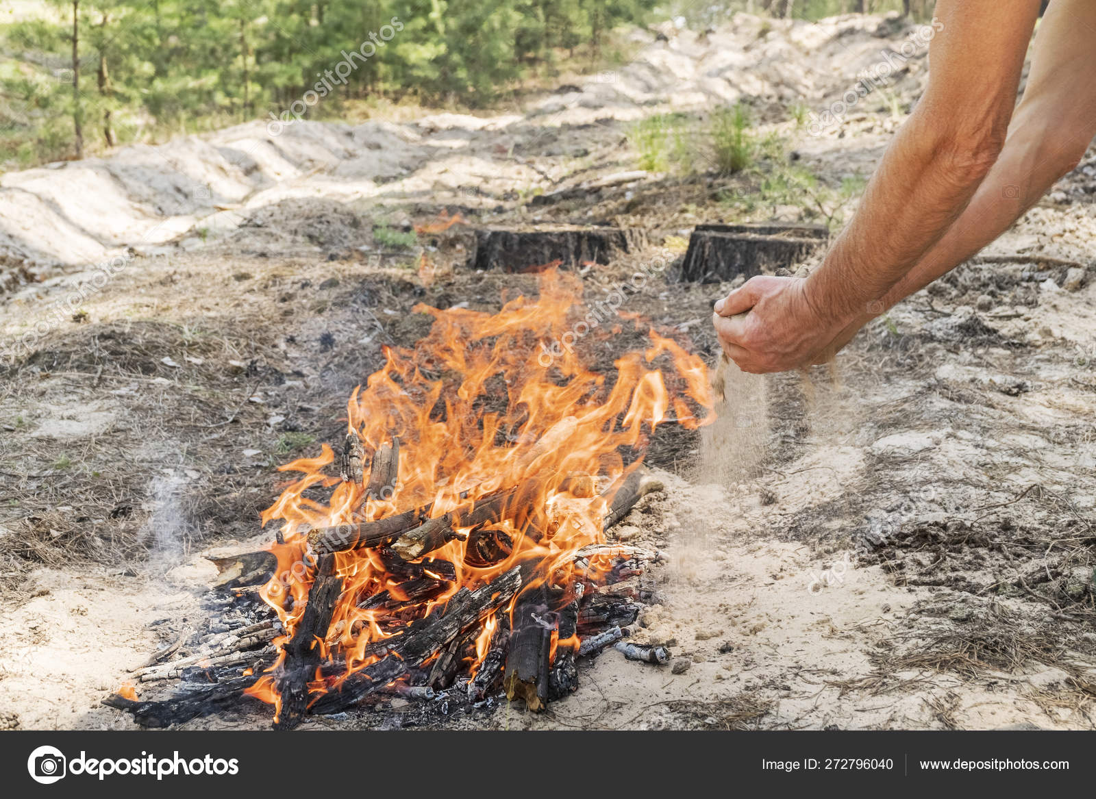 Man putting out a fire with sand — Stock Photo © GrashAlex #272796040