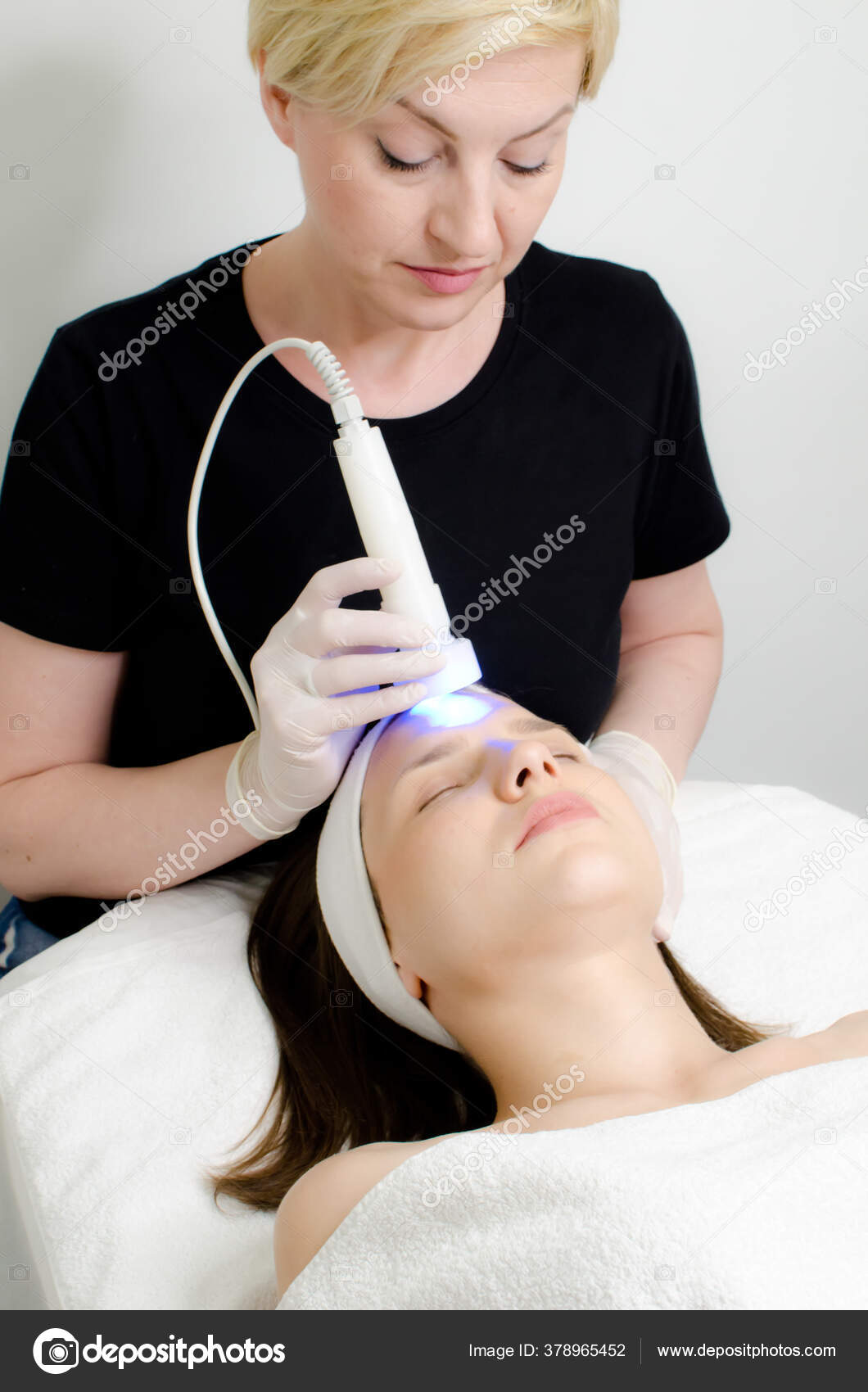 Blonde Beautician Applying Blue Led Light Therapy Female Customer ...