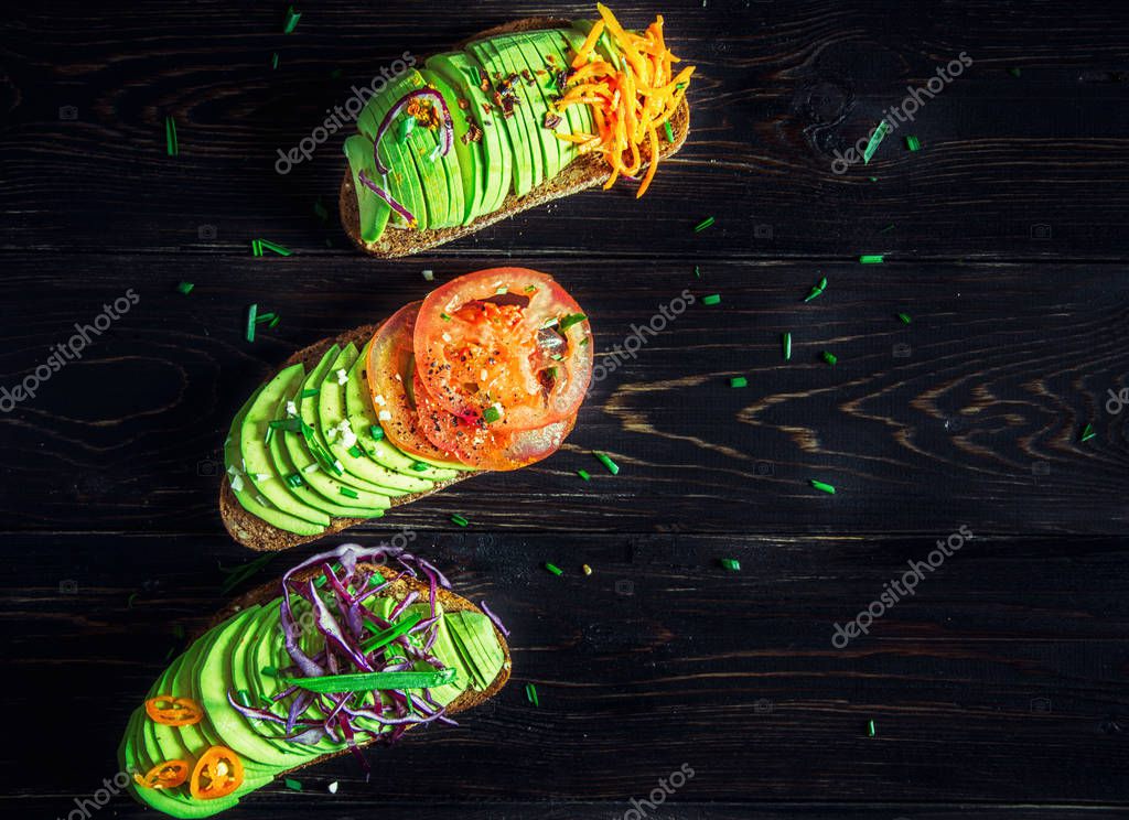 las piezas de aguacate en el crujiente pan integral con tomate 2022