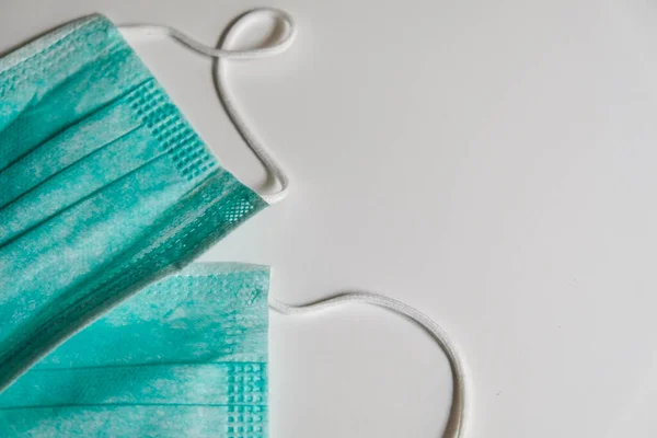 Two standard blue face medical masks on a white table. Self protection ...