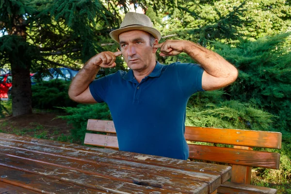 Middle Age Man Sitting o Bench in Park With Fingers of Both Hands in ...