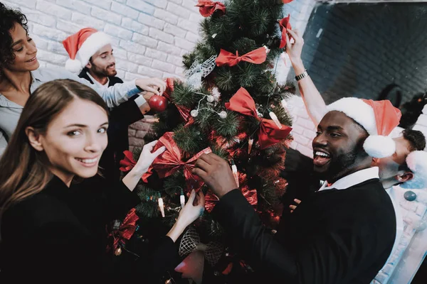 Happy Workers Decorating Christmas Tree in Office. New Year Eve ...
