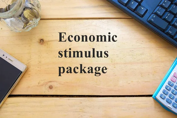 Texts Economic stimulus package on wooden background. Conceptual ...