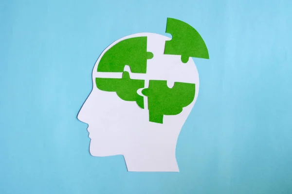 Green jigsaw puzzle as a human brain on blue background, Memory loss ...
