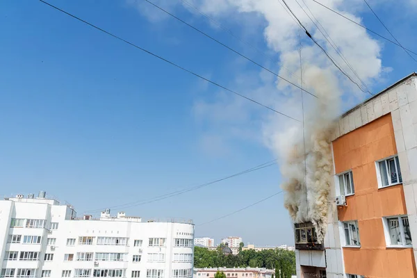 fire on the balcony of a multi-storey building, black clouds of smoke ...