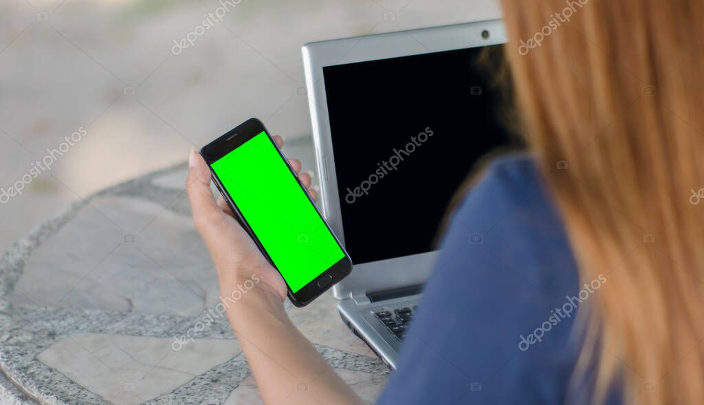 Vista trasera. Las mujeres est n sentadas en la mesa de m rmol y usando un tel fono inteligente ...