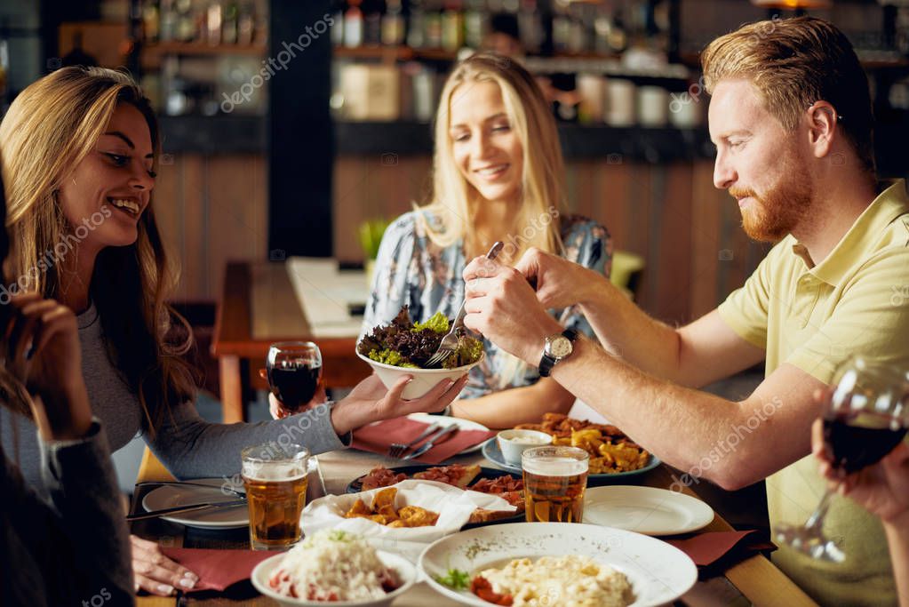 Amigos cenando en el restaurante. Grupo multiétnico. 2024