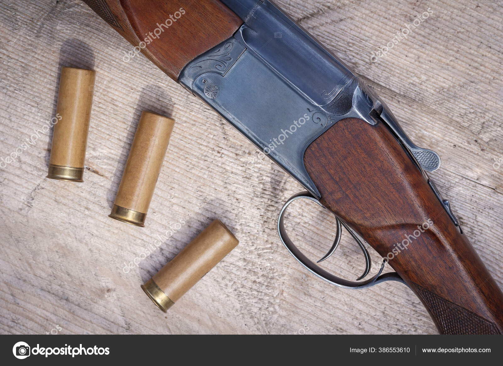 Shotgun forearm with two triggers top view. Rifle charges or cartridges on a wooden surface ...