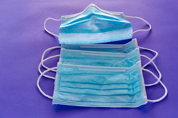 Blue medical face mask to avoid contagious diseases pattern on purple ...