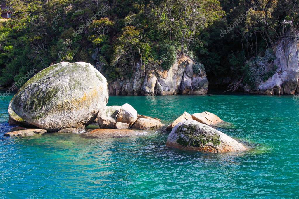 Vista hacia una laguna aislada con rocas en agua turquesa y fondo de ...