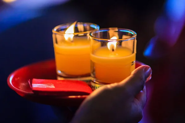 Poor light with noise grain of hand holding candles in the transparent ...