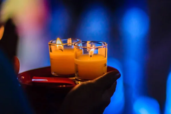 Poor light with noise grain of hand holding candles in the transparent ...