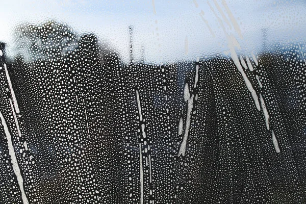 Window glass in foam. Detergent on glass, dirty surface. Soap texture ...