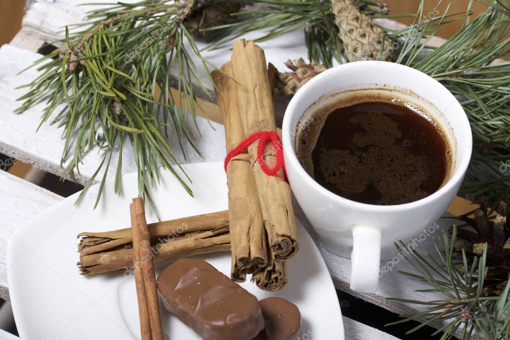 Una taza de café, palitos de canela y chocolate junto a las ramitas de ...