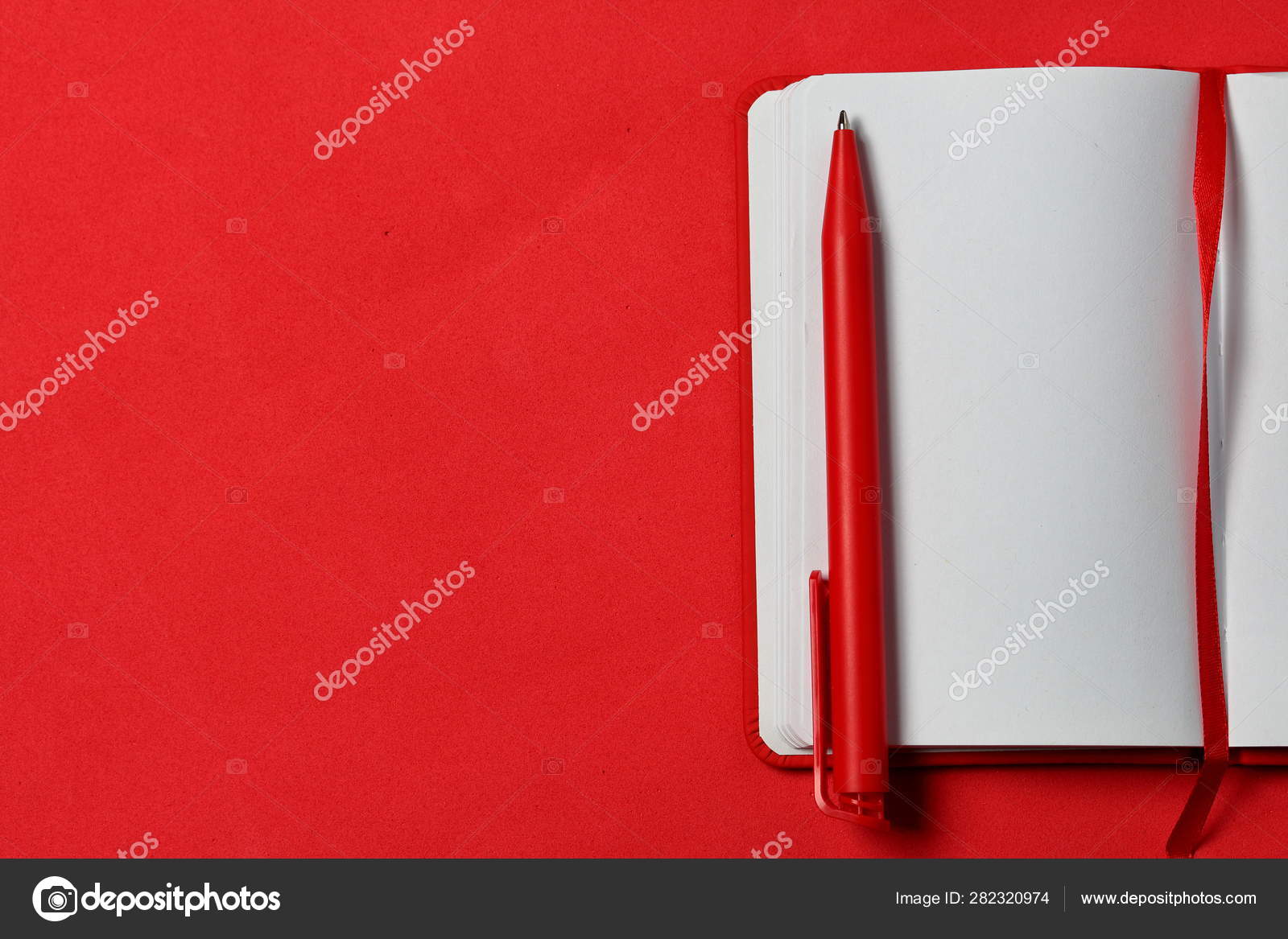Notebook for notes in the red cover. With a red bookmark and pen. Lies ...