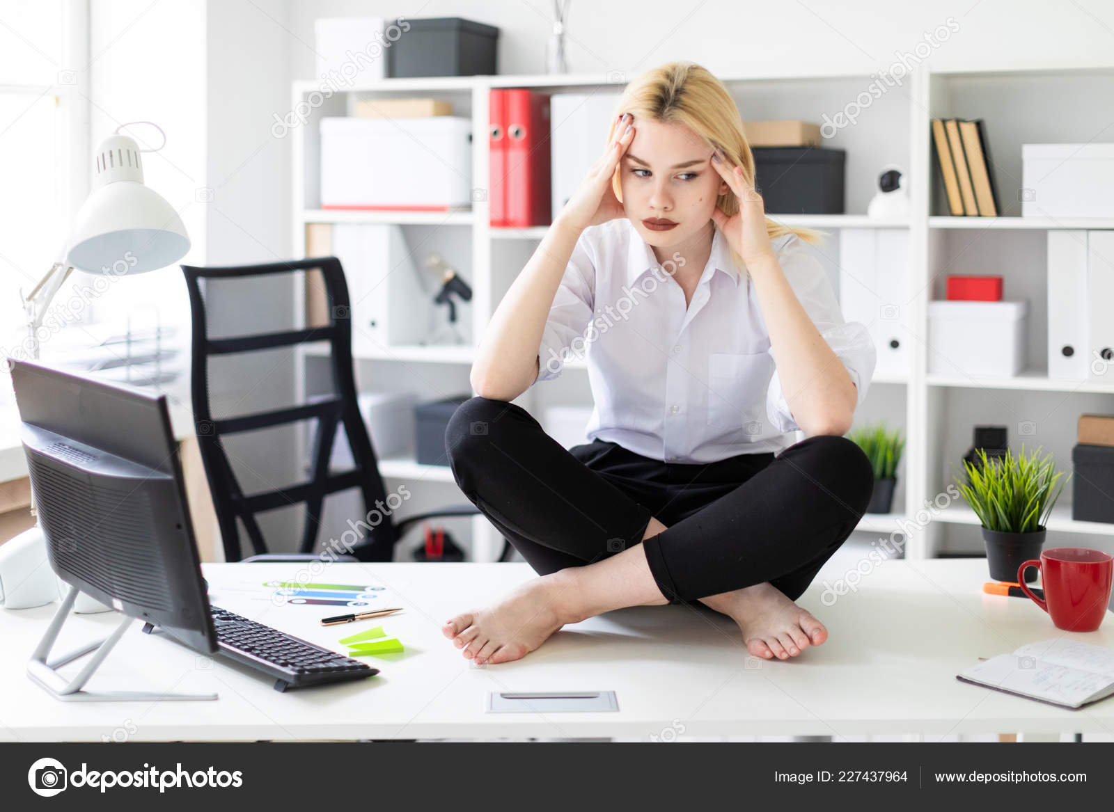 A young girl sitting on a table in the office. — Stock Photo ...