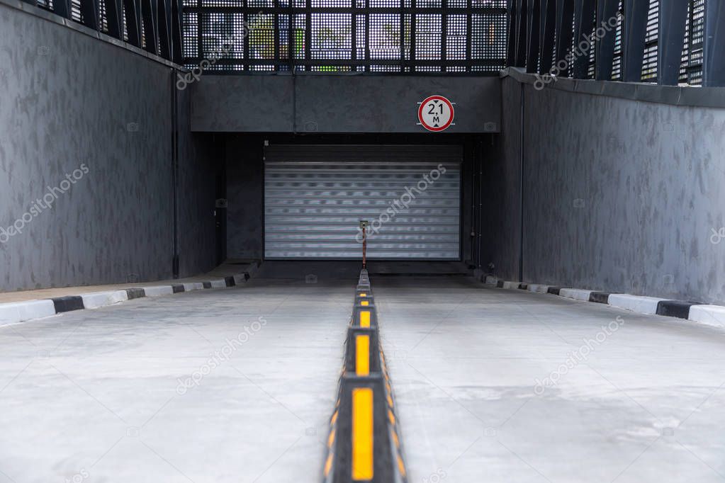 Entrada al aparcamiento subterráneo con puerta enrollable y divisores de carreteras 2022
