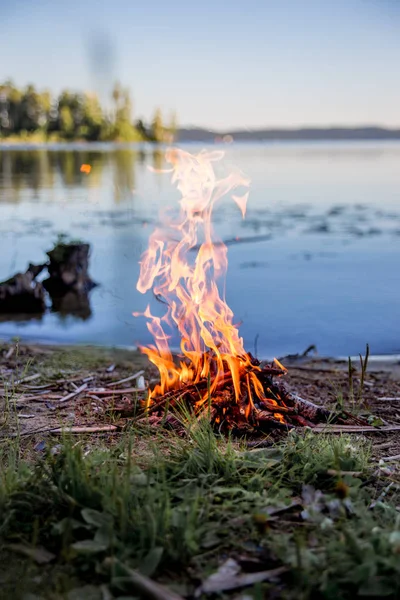 Beautiful campfire in the evening at lake. Fire burning in dusk at ...