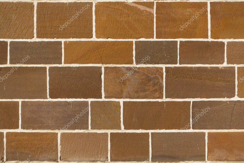 Una pared con diferentes tonos de ladrillo marrón con líneas de mortero ...