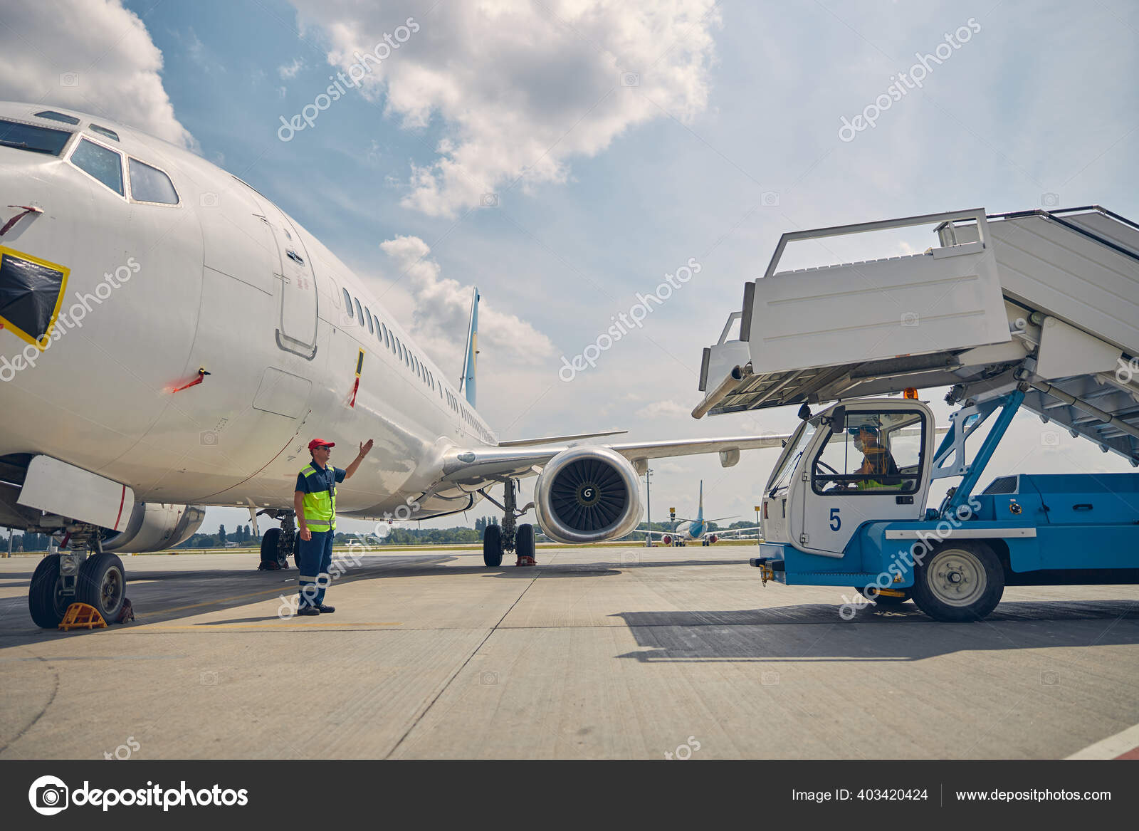 Experienced airport worker directing the ground vehicle operator ...