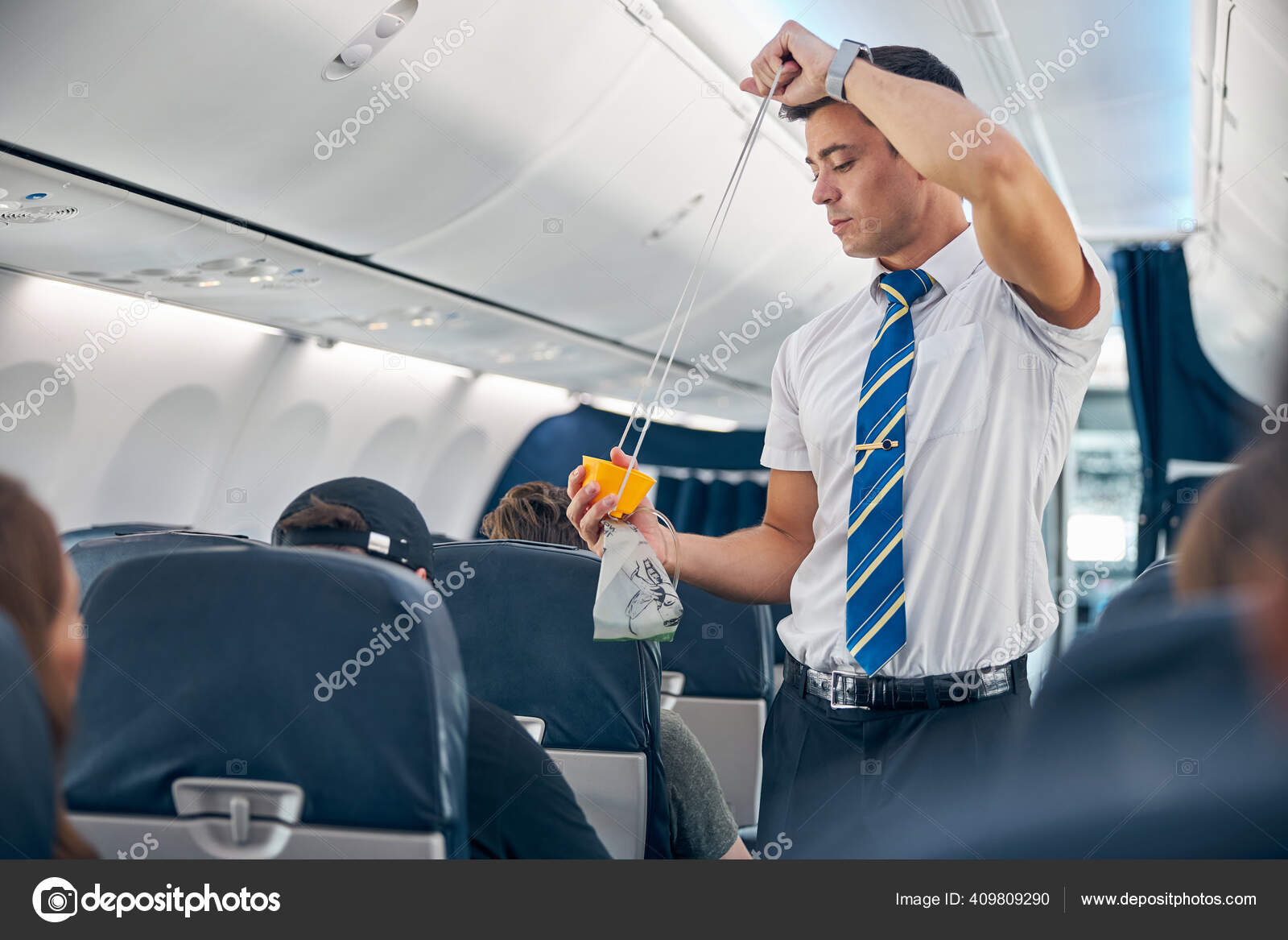 Man with oxygen mask demonstrating safety procedure prior to passenger ...