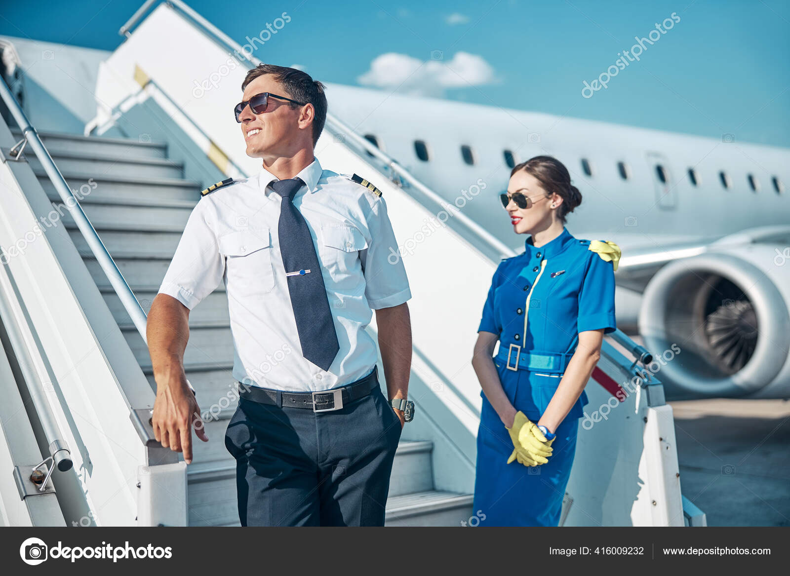 Cheerful pilot and stewardess standing on stairway — Stock Photo ...
