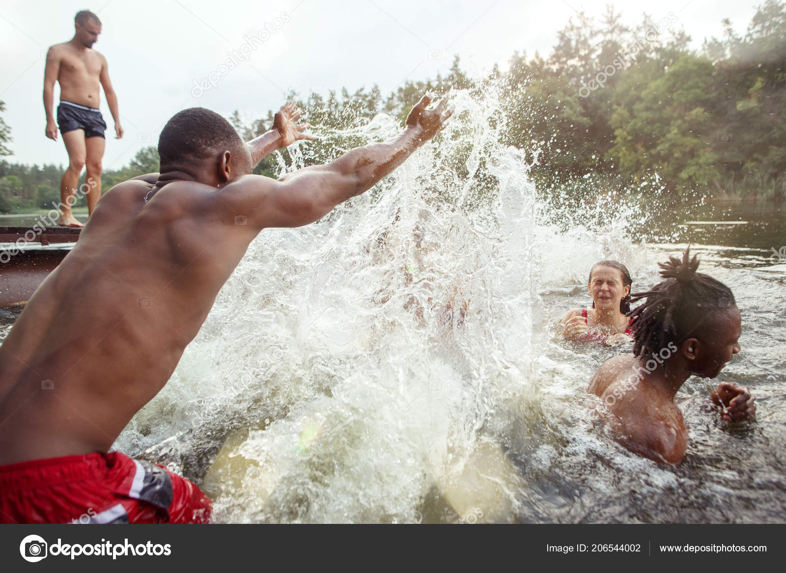 Enjoying river party with friends. Group of beautiful happy young people at the river together ...