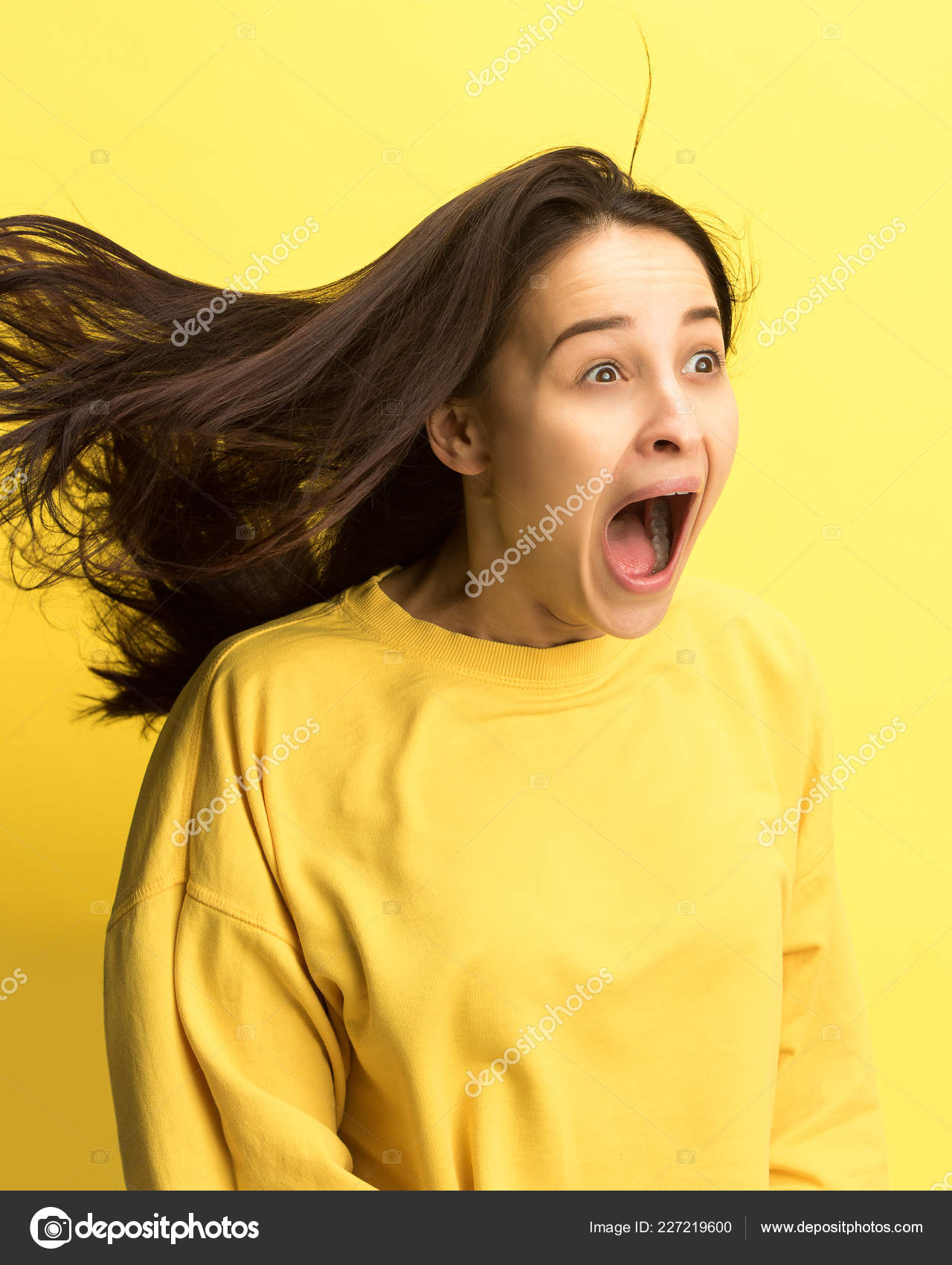 The woman screaming with open mouth isolated on yellow background ...