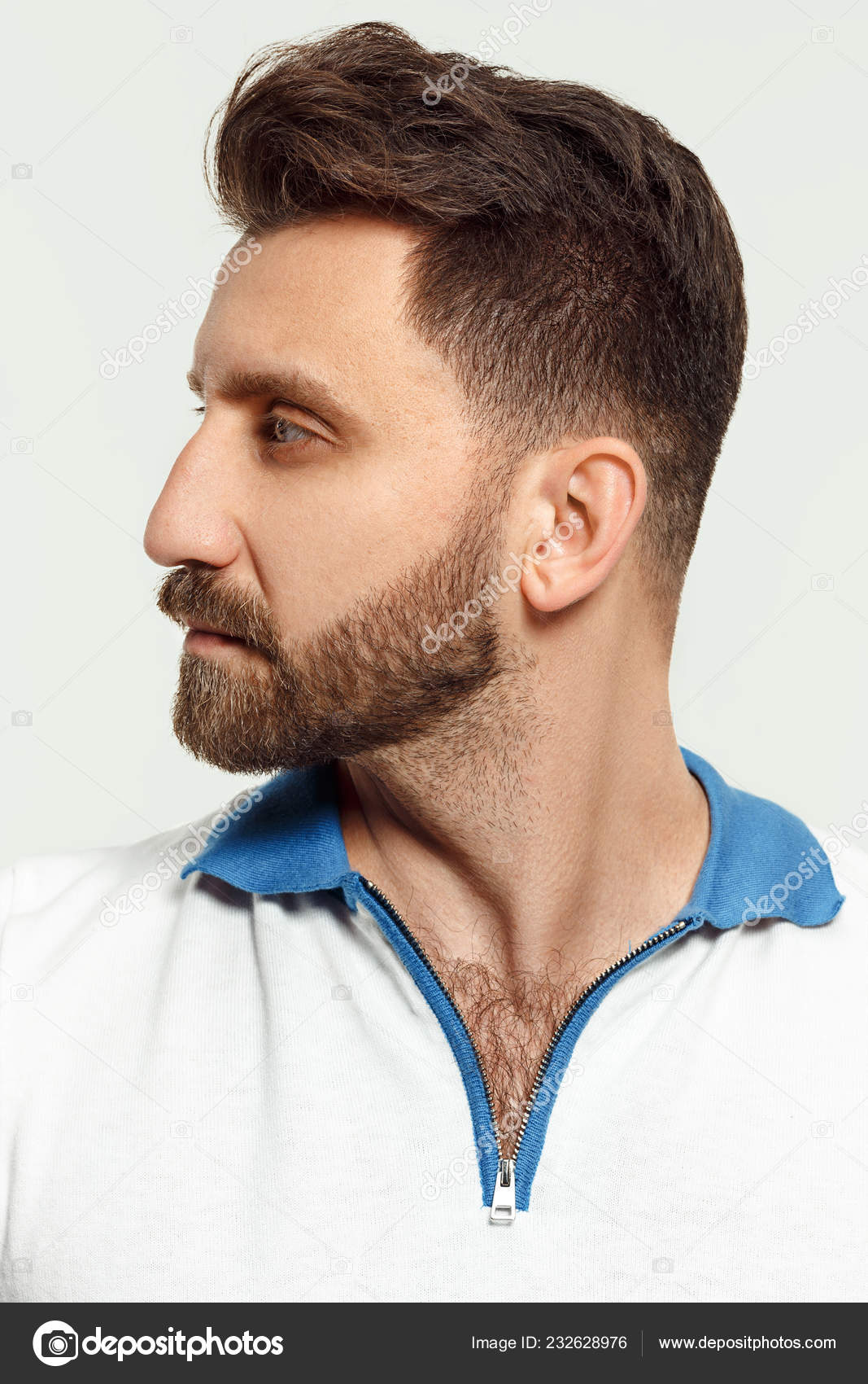 The serious man standing and looking at camera against white background ...