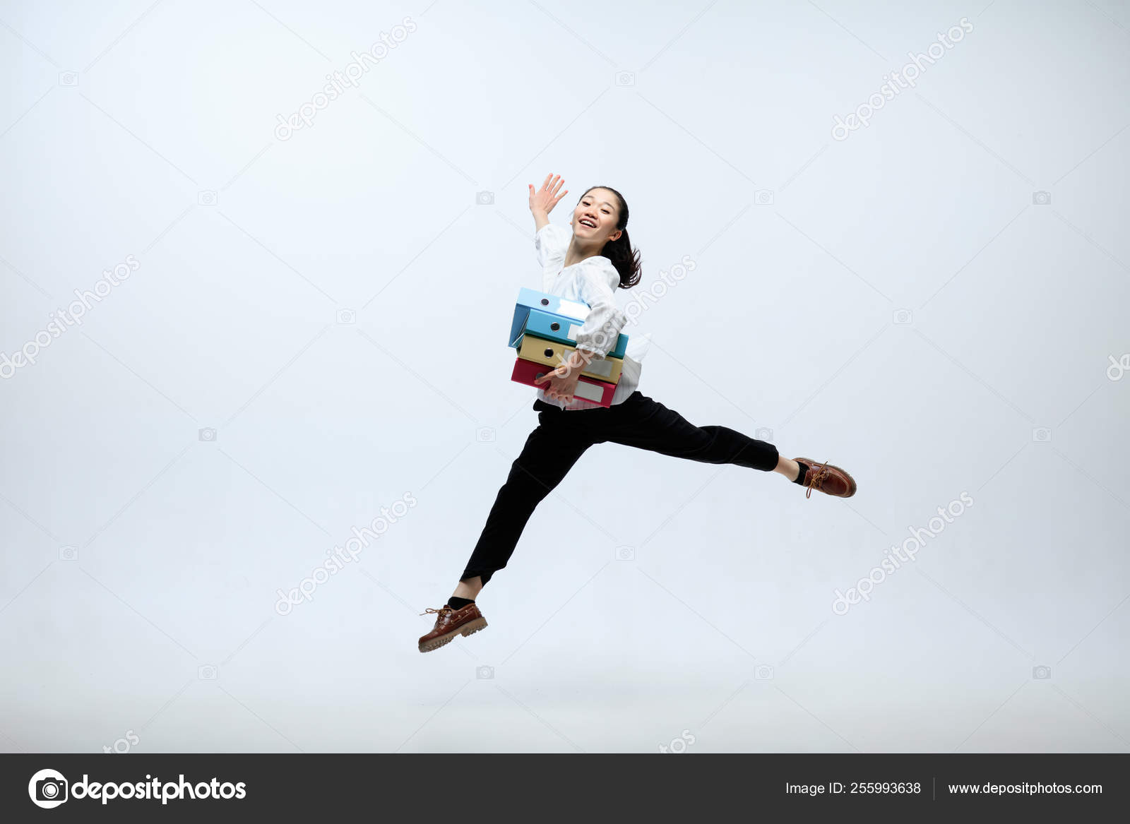 Woman working at office and jumping isolated on studio background ...