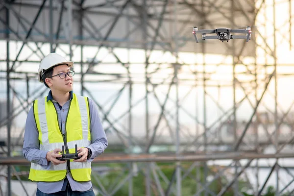 Asian engineer flying drone over construction site - Stock Image ...