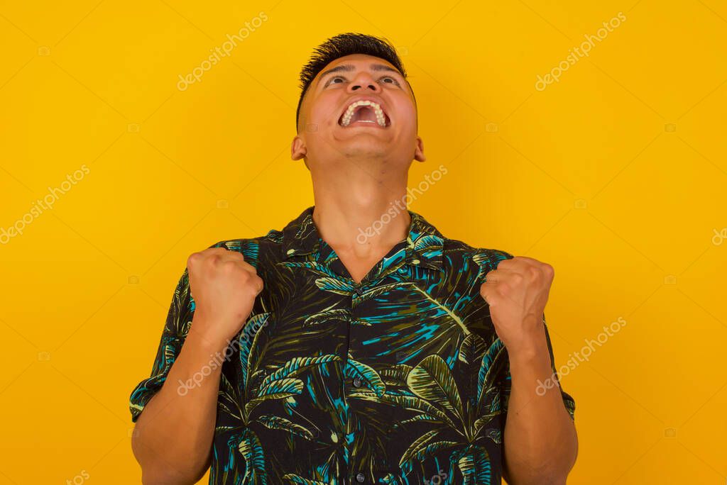 Portrait of handsome hispanic male looks with excitement up, keeps ...