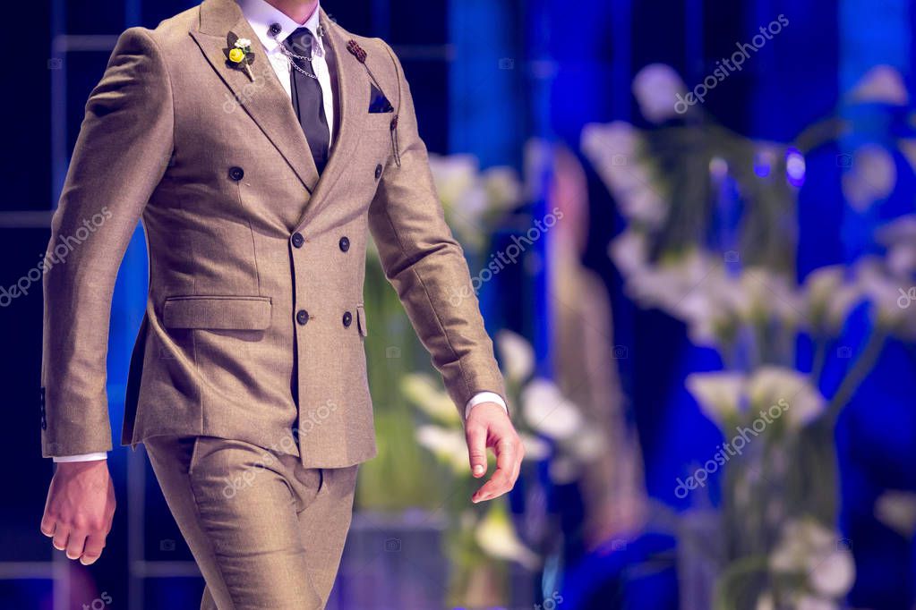 Modelo masculino camina por la pasarela en traje beige durante un ...