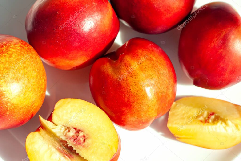Frutos de nectarina orgánica madura roja en el plato blanco en el fondo ...