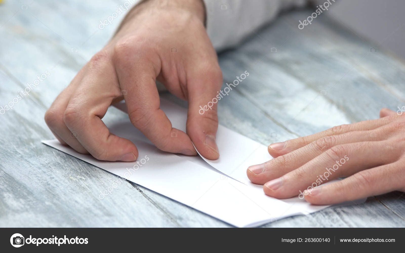 Male hands folding white paper sheet. Stock Photo by ©Denisfilm 263600140