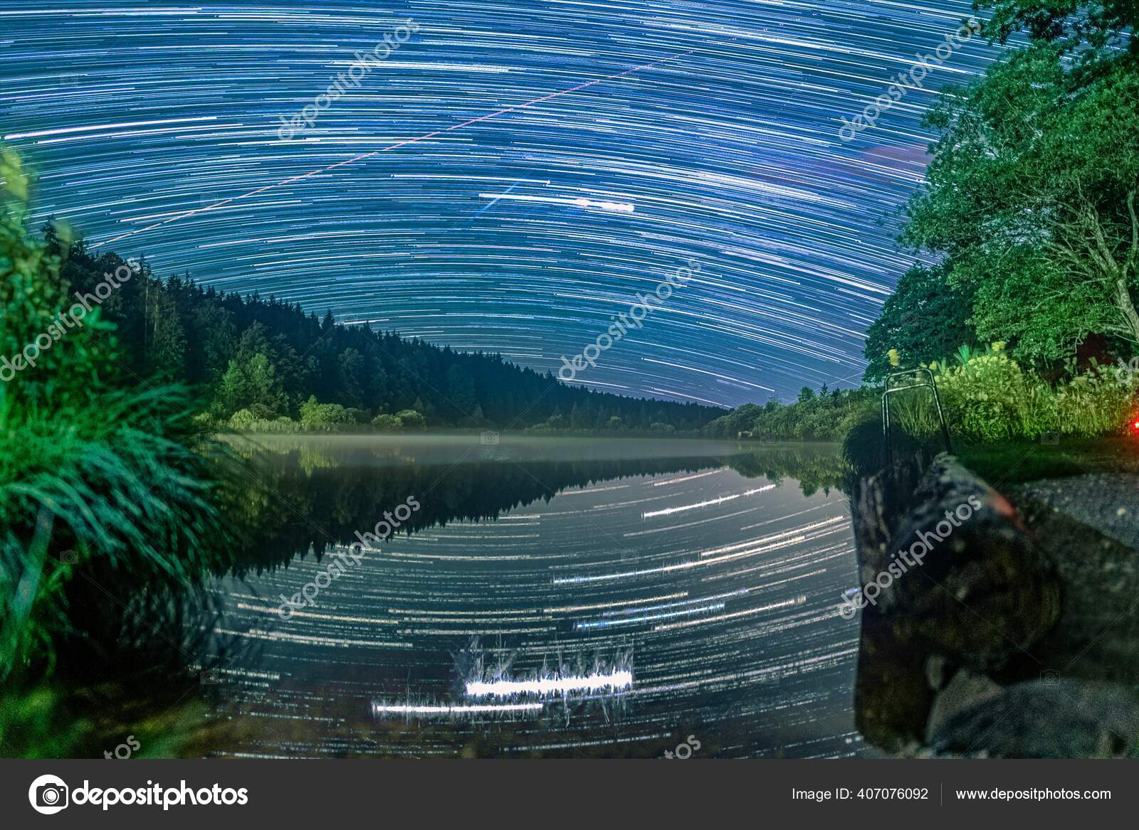 Long Exposure Startrails over an idyllic lake with star reflections in ...
