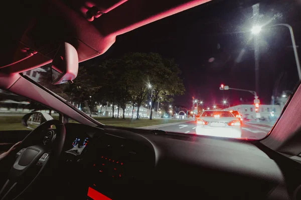 Car drive on the road traffic in night city. Red stop signal backlight ...