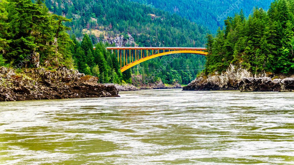 El poderoso río Fraser, con la estructura de acero en forma de arco del puente Alexandra en la ...