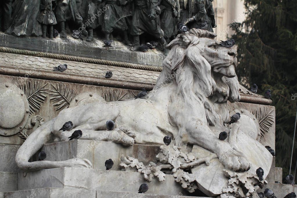 Grupo de palomas en la estatua de la cabeza del león en la Piazza Duomo ...
