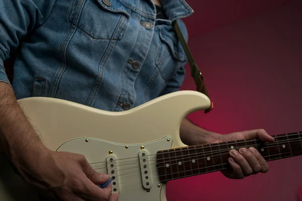 Man playing white electric guitar on a jean jacket - Stock Image ...