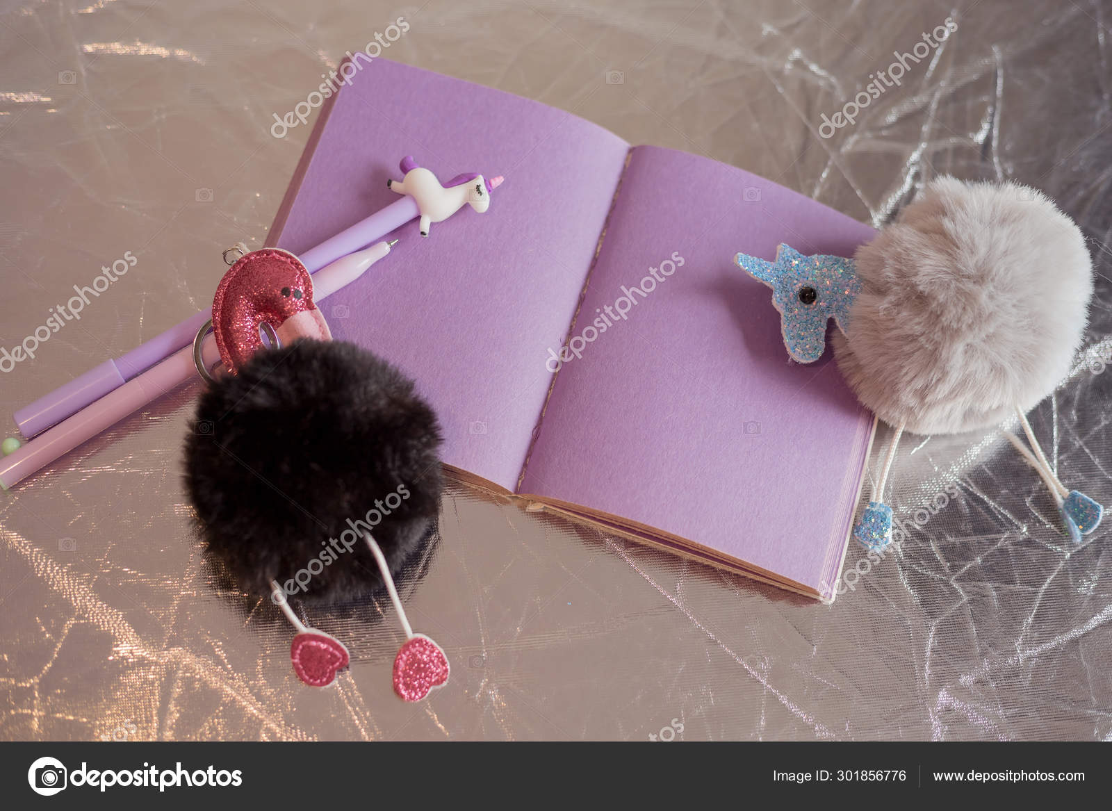Girlish things still life. Notepad with purple pages, a fluffy b ...