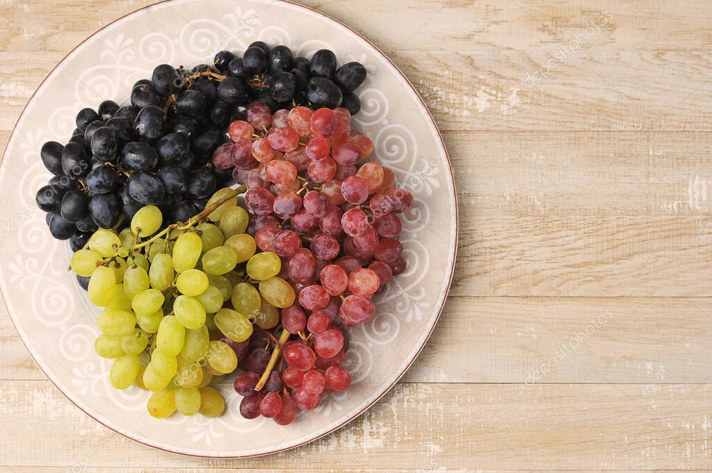 racimos de uvas verdes rojas y negras en un plato - vista superior 2024