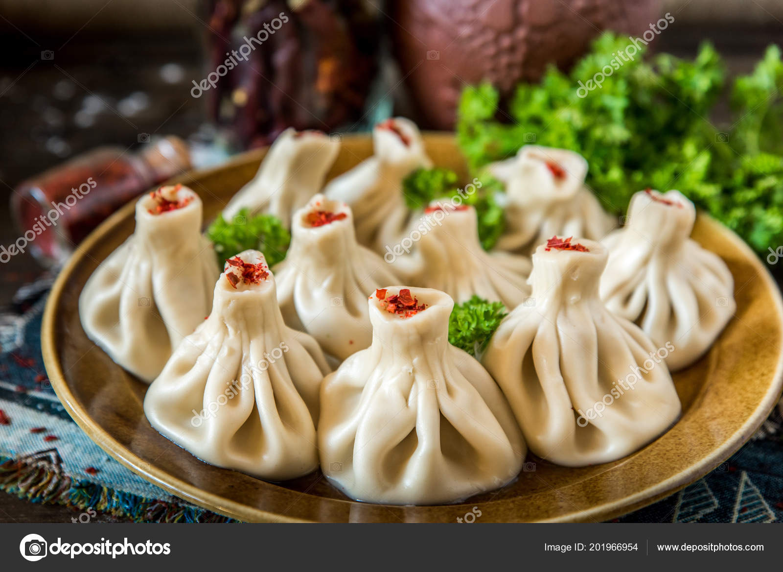Georgian dumplings Khinkali with meat and red papper, on brown plate ...