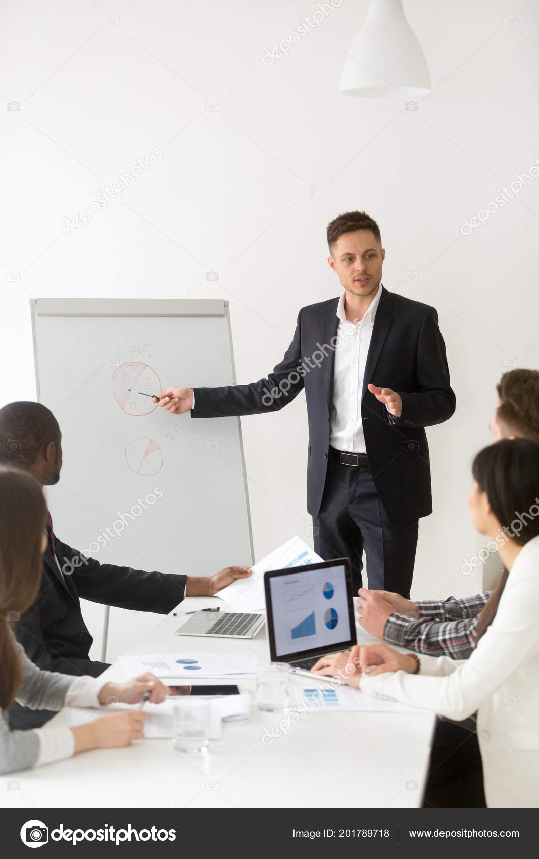 Caucasian worker making presentation in front of diverse work gr ...