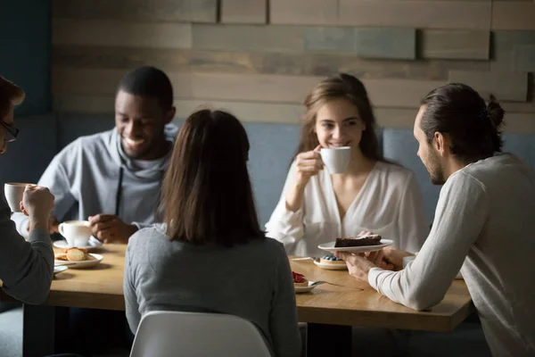 Smiling diverse friends enjoying coffee and desserts in cafe - Stock ...