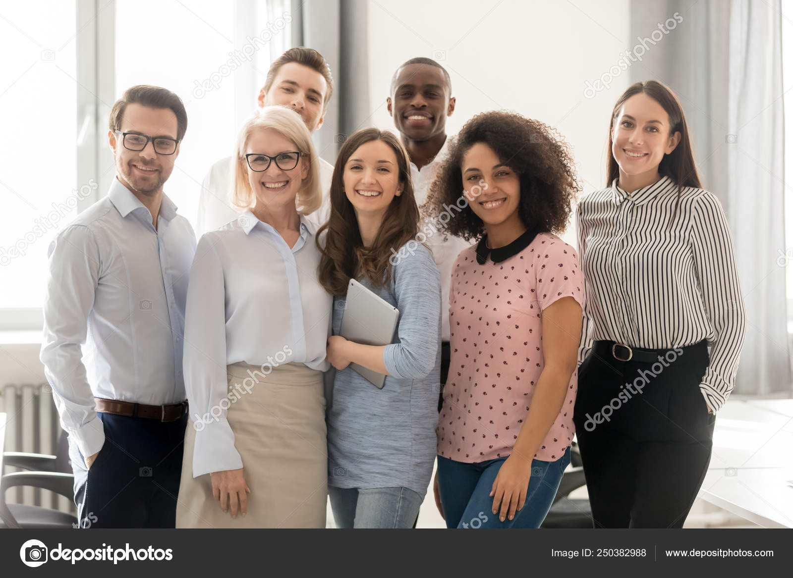 Happy multicultural work team looking at camera posing in office ...